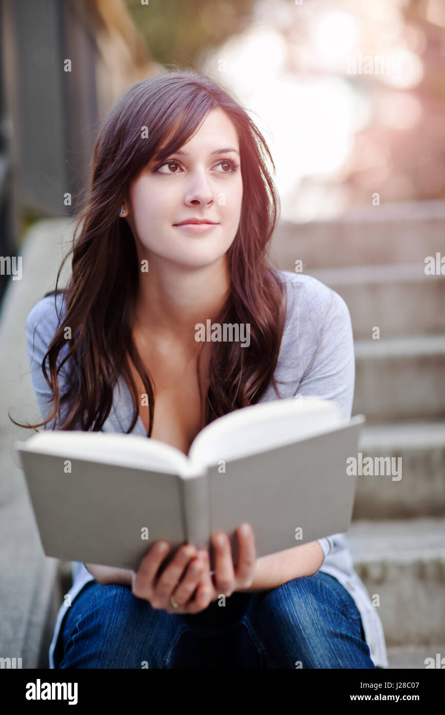 A shot of a smiling college student reading a book Stock Photo - Alamy