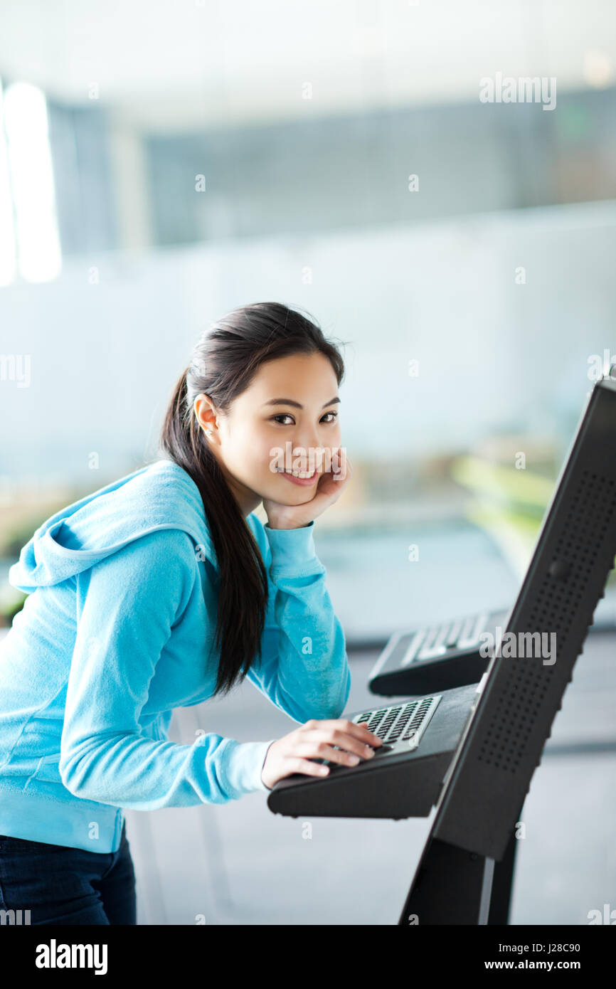 A shot of an Asian college student using a computer kiosk Stock Photo ...
