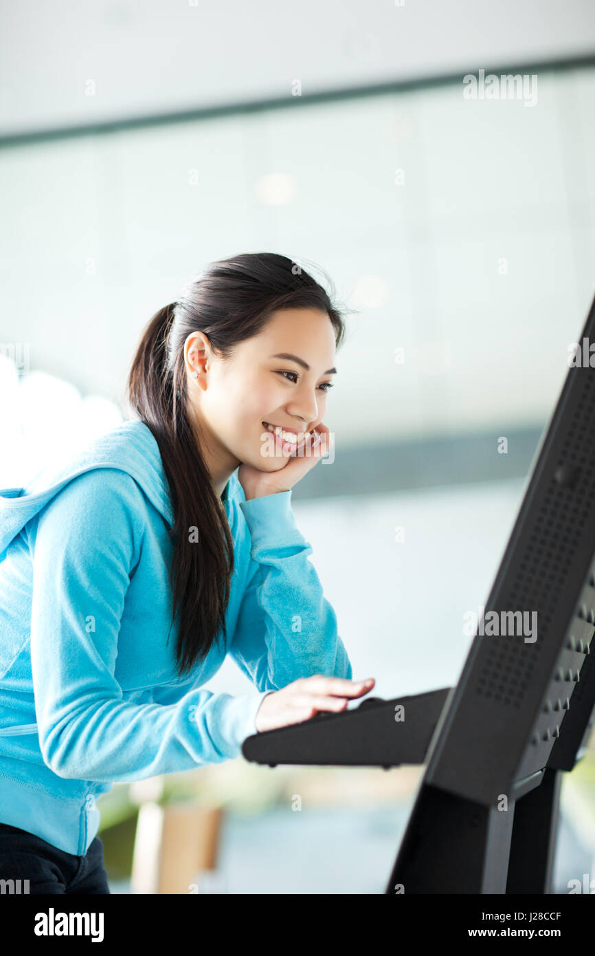 A shot of an Asian college student using a computer kiosk Stock Photo ...