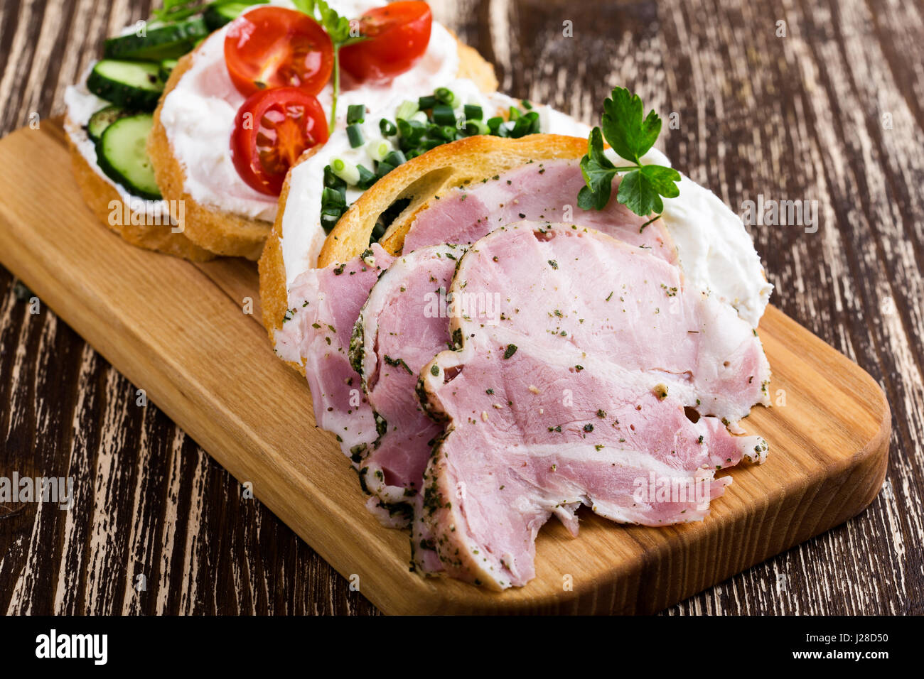 Assorted sandwiches with cream cheese, ham,cucumbers, tomatoes and ...