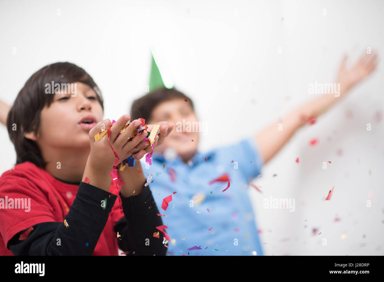 Happy kids celebrating party with blowing confetti Stock Photo - Alamy