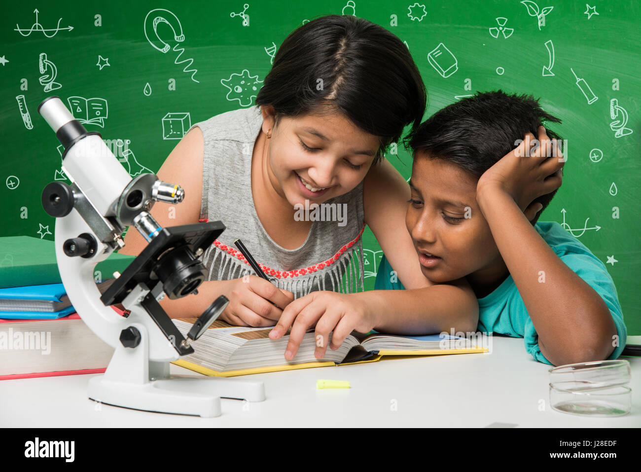 cute indian kids doing science experiment in chemistry lab or biology ...