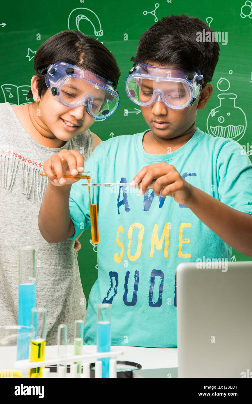 cute indian kids doing science experiment in chemistry lab or biology ...