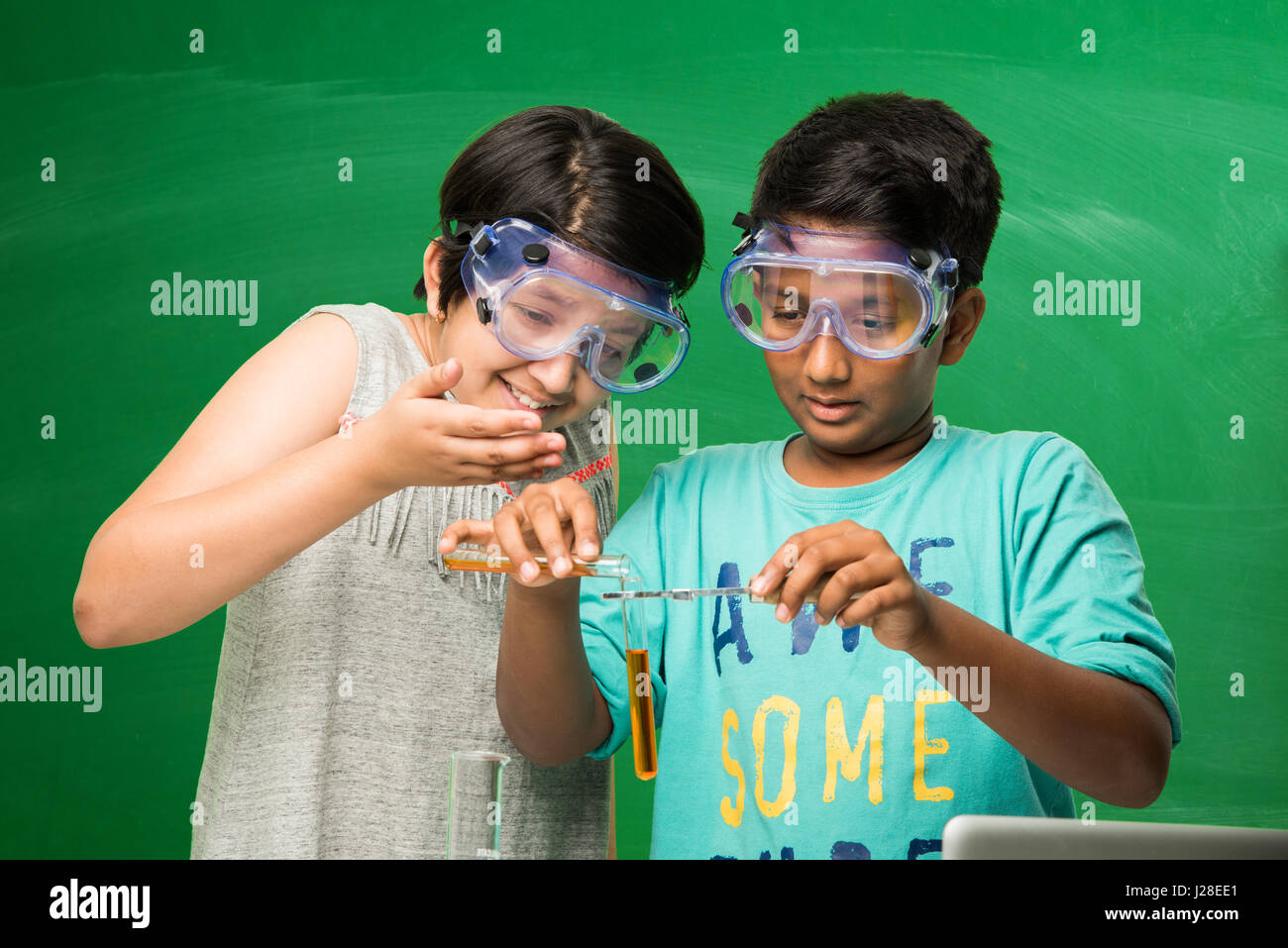 cute indian kids doing science experiment in chemistry lab or biology ...