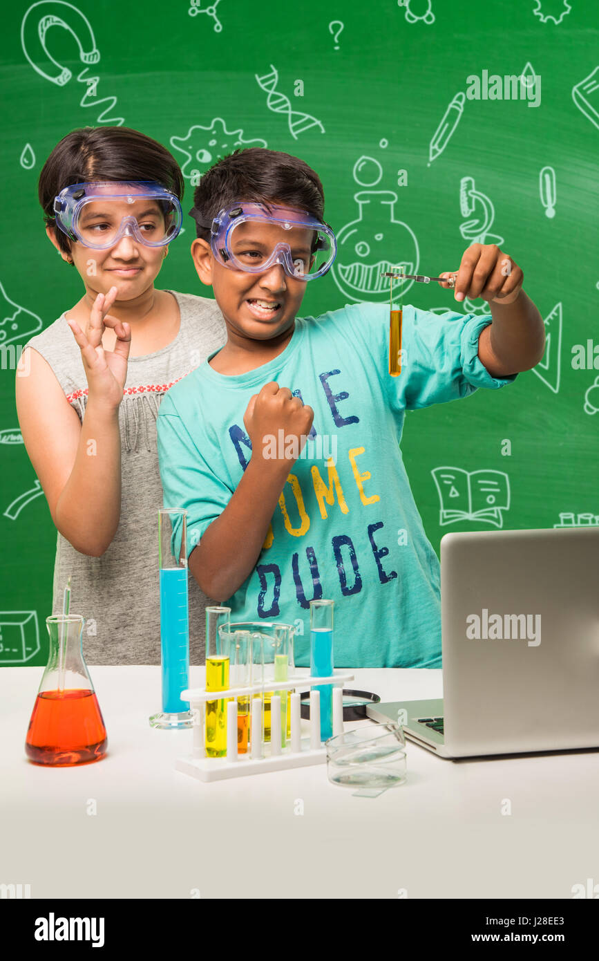 cute indian kids doing science experiment in chemistry lab or biology ...