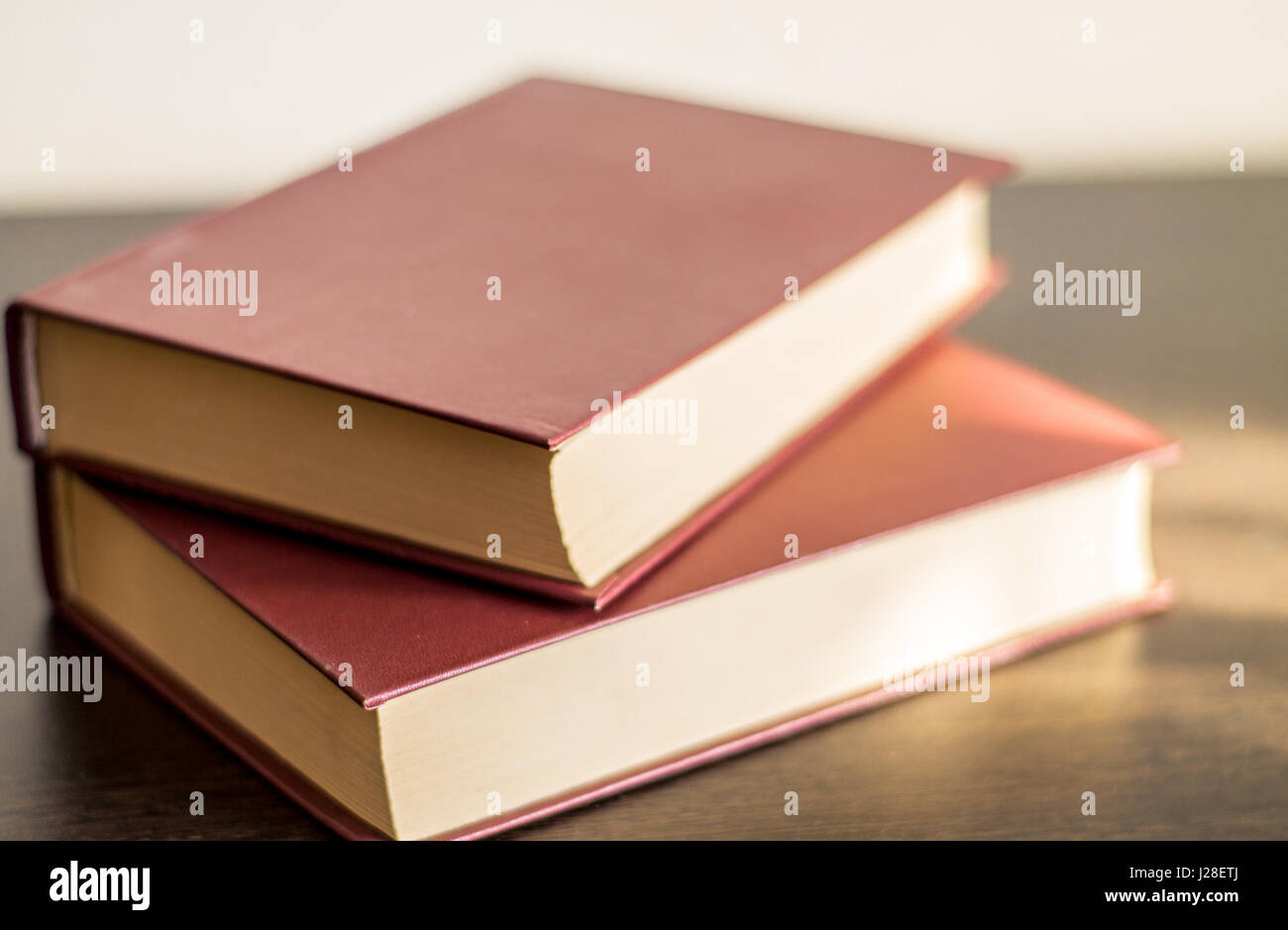 Two books on an empty wooden table Stock Photo - Alamy
