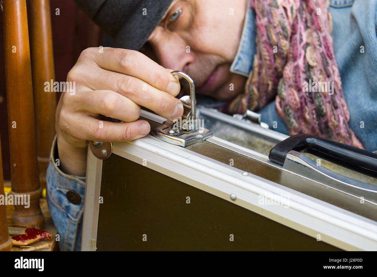 Male, seems like a thief opening a briefcase, closeup cropped shot ...