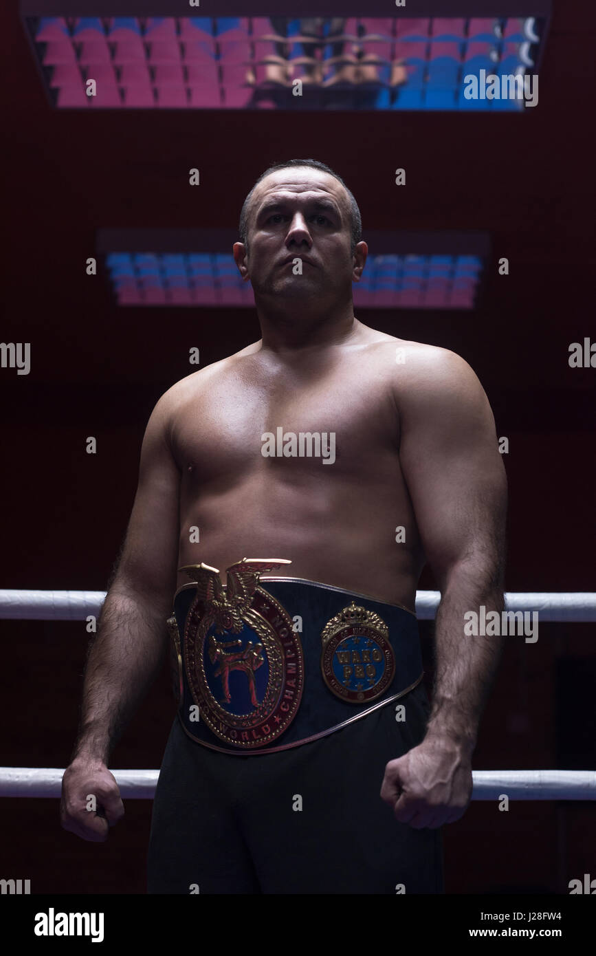 portrait of muscular professional kick boxer with his championship belt ...