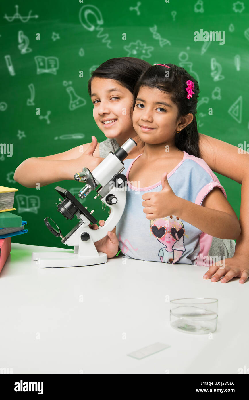 cute indian kids doing science experiment in chemistry lab or biology ...