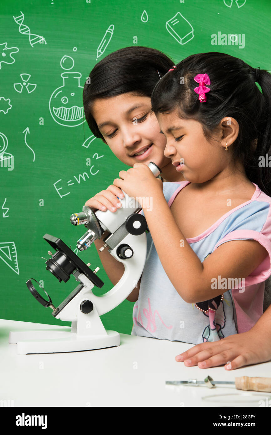 cute indian kids doing science experiment in chemistry lab or biology ...
