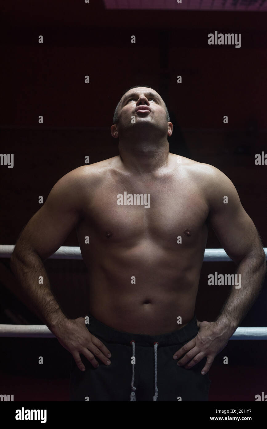portrait of muscular professional kickboxer who standing in the ring ...