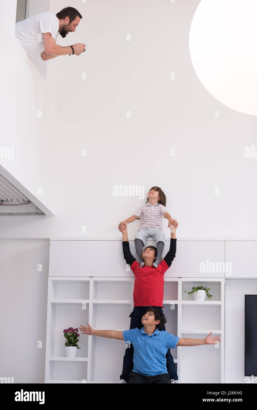 happy young boys having fun and posing line up piggyback in new modern ...