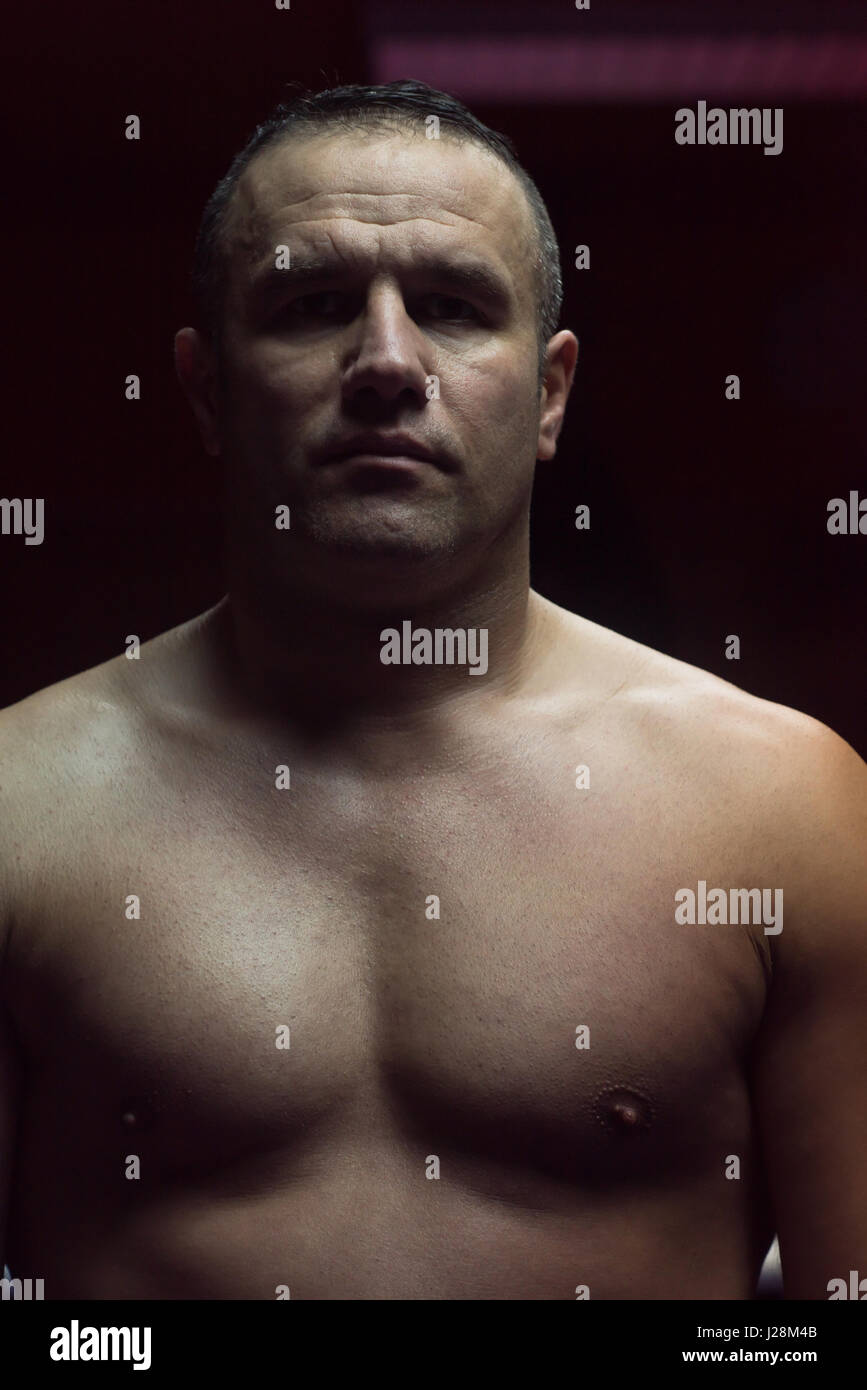 portrait of muscular professional kickboxer who standing in the ring ...