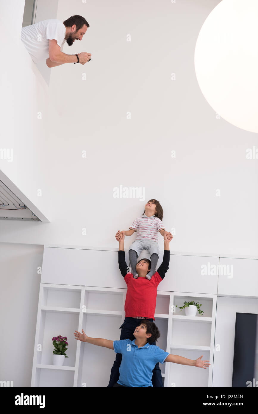 happy young boys having fun and posing line up piggyback in new modern ...
