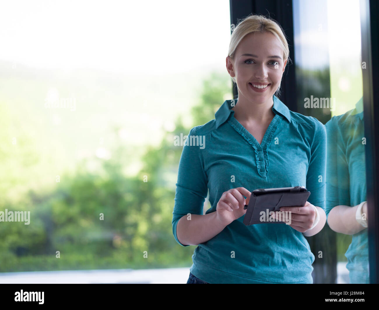 beautiful young women using tablet computer by the window of her luxury ...