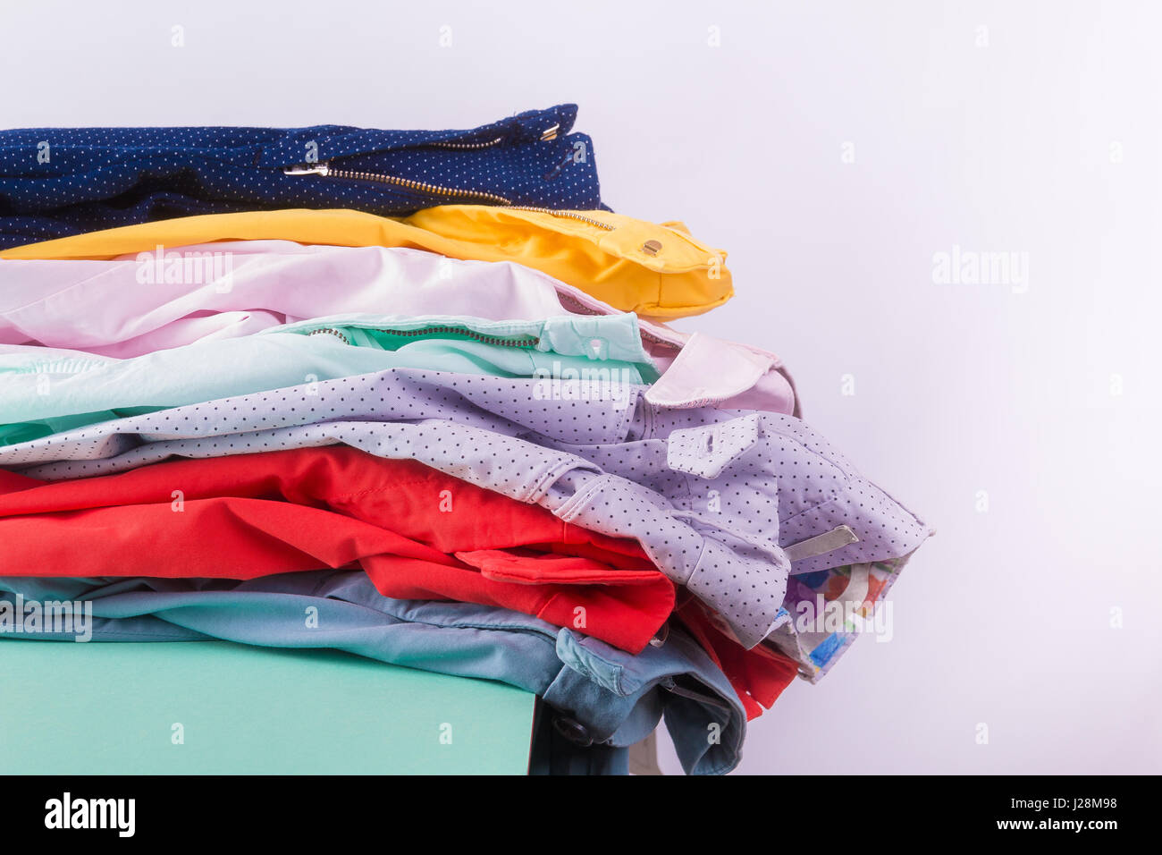 Folded colorful pants and jeans. Stack of bright female trousers. Close ...