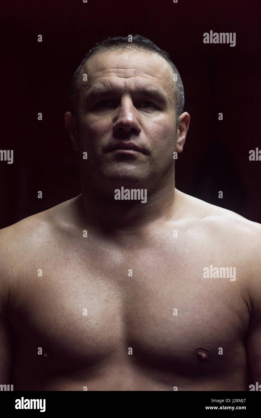 portrait of muscular professional kickboxer who standing in the ring ...