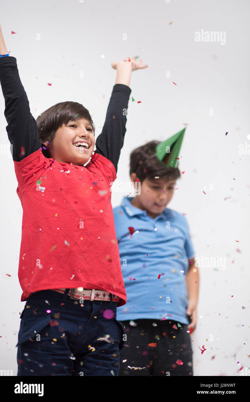 Happy kids celebrating party with blowing confetti Stock Photo - Alamy