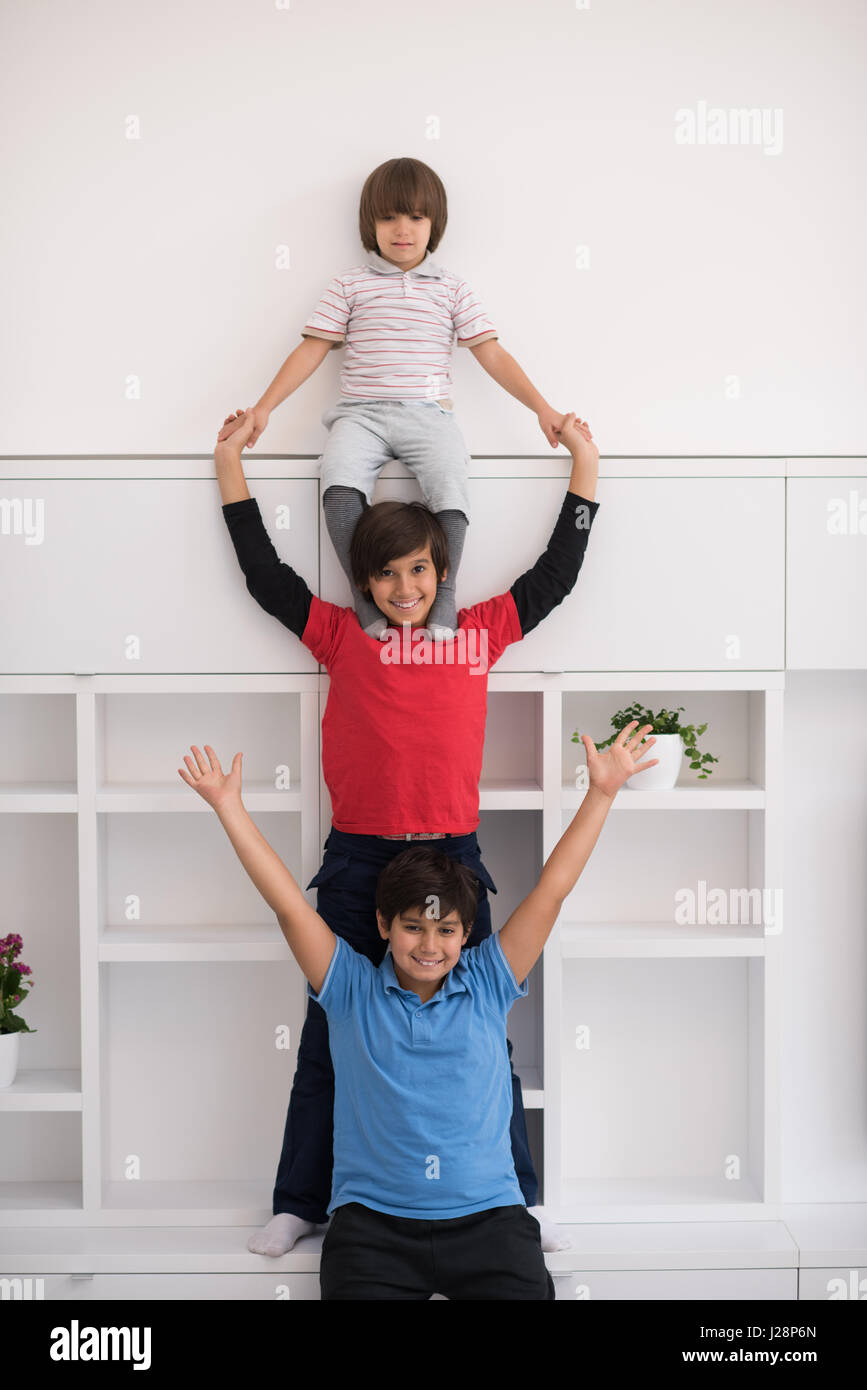 happy young boys having fun and posing line up piggyback in new modern ...
