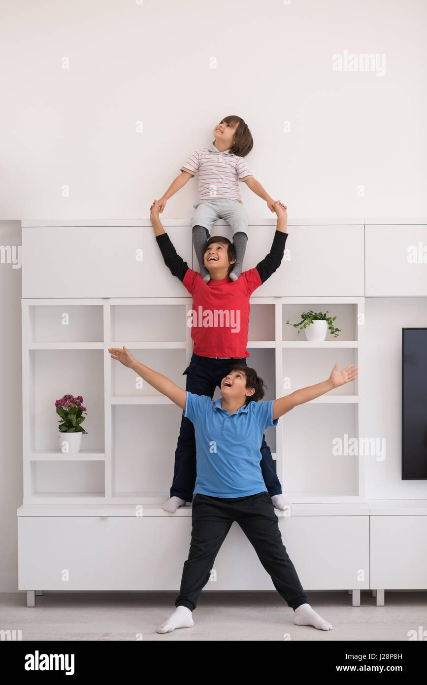 happy young boys having fun and posing line up piggyback in new modern ...