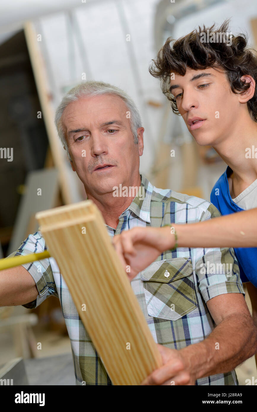 Carpenters measuring plank of wood Stock Photo - Alamy