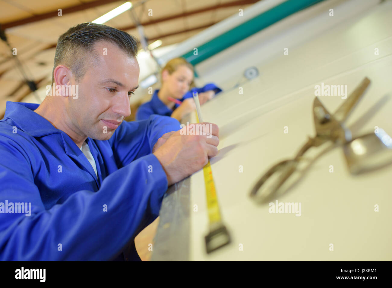 Man measuring material and marking place to cut Stock Photo - Alamy