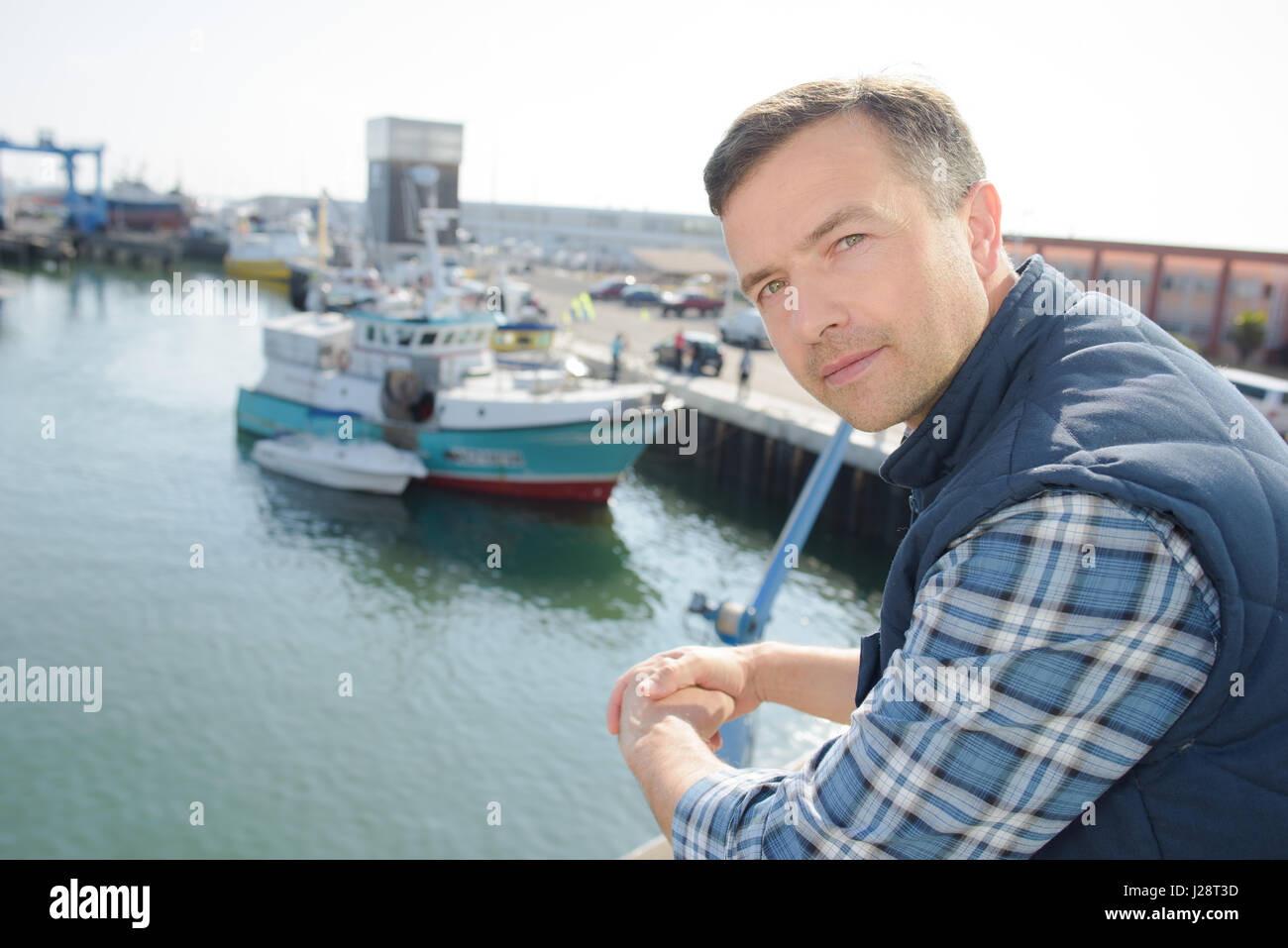 Man looking out over docks Stock Photo - Alamy