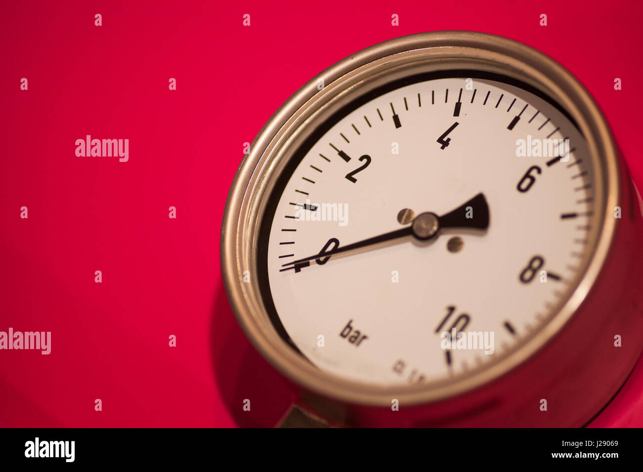 Close up shot of a pressure gauge on a red background Stock Photo - Alamy