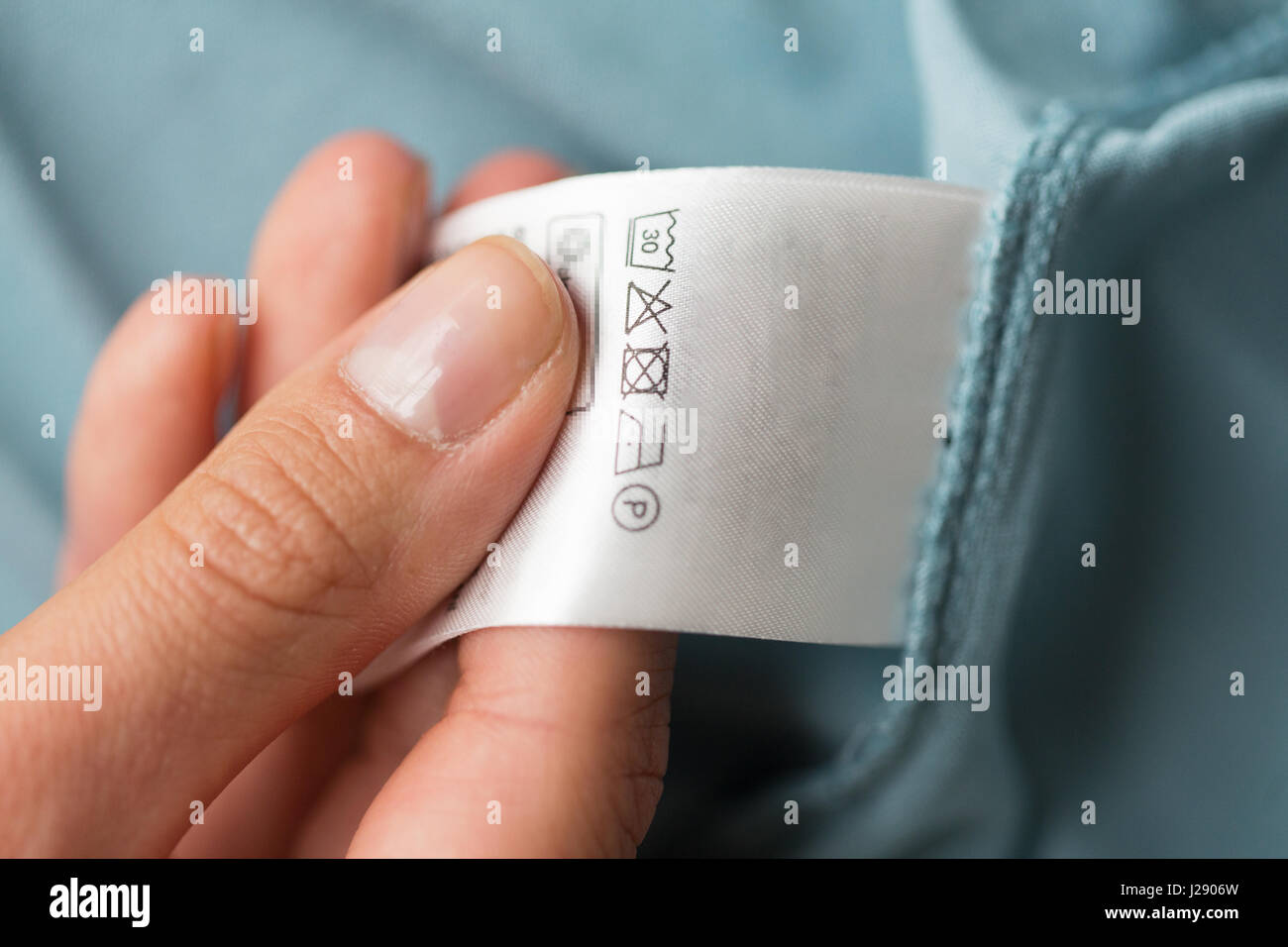 hand holding label with users manual of clothing Stock Photo - Alamy