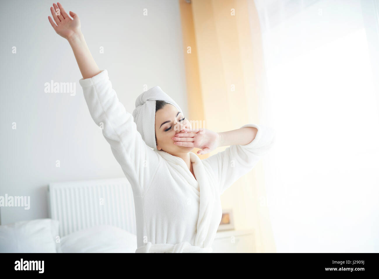 Young woman yawning and stretching Stock Photo - Alamy