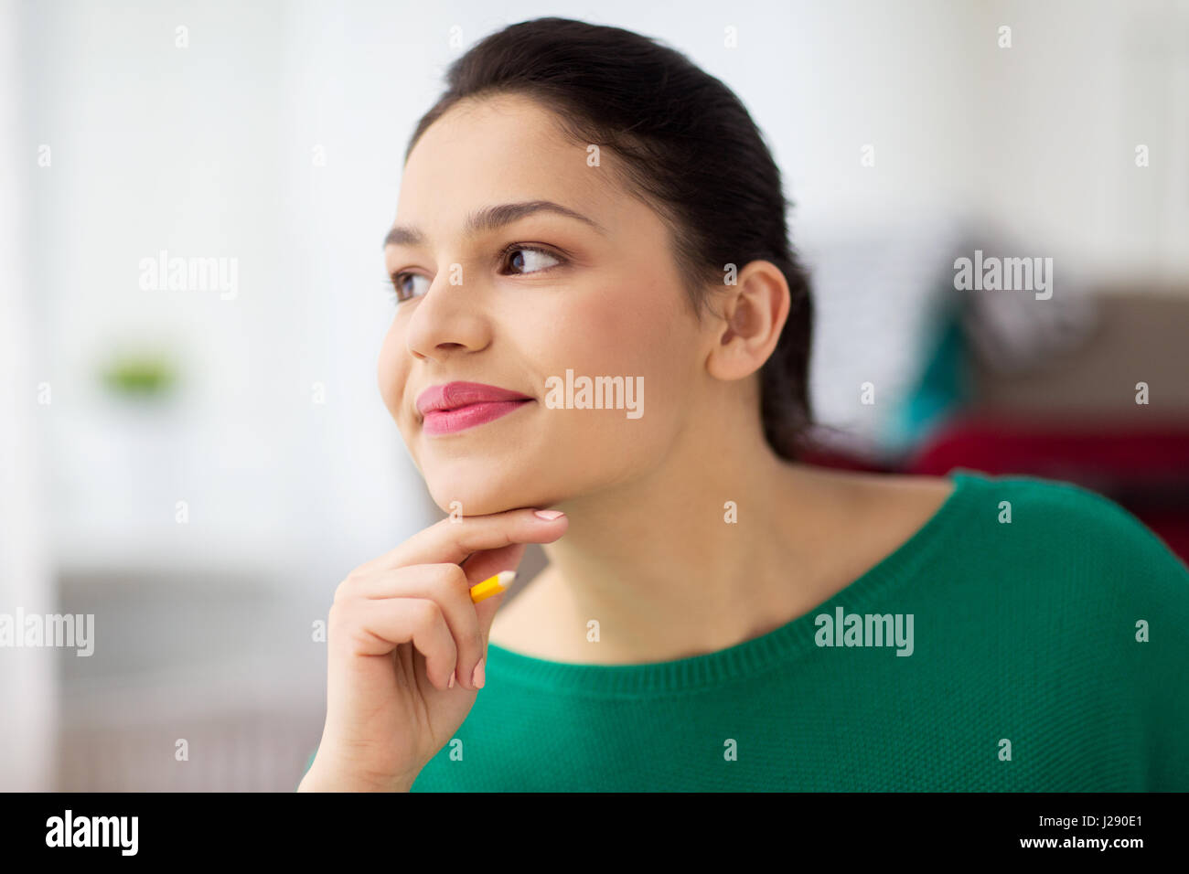 happy young woman with pencil thinking Stock Photo - Alamy