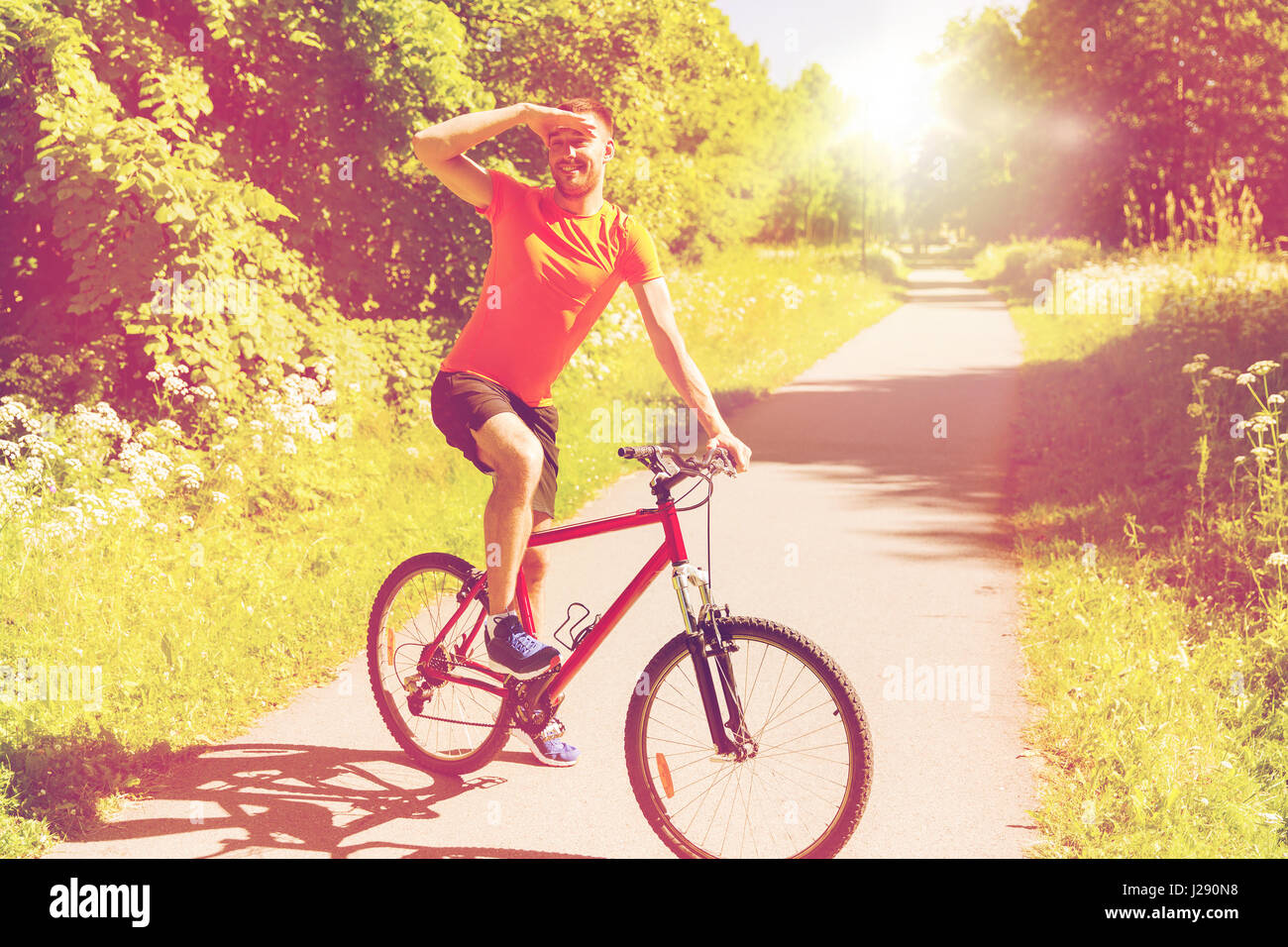happy young man riding bicycle outdoors Stock Photo - Alamy