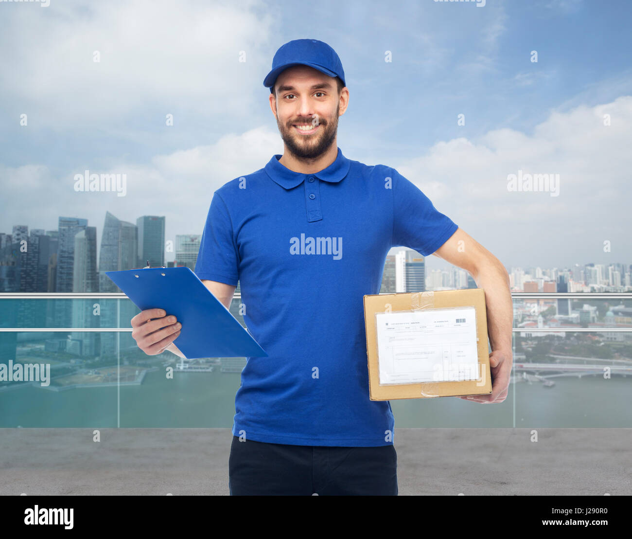 happy delivery man with parcel box and clipboard Stock Photo - Alamy