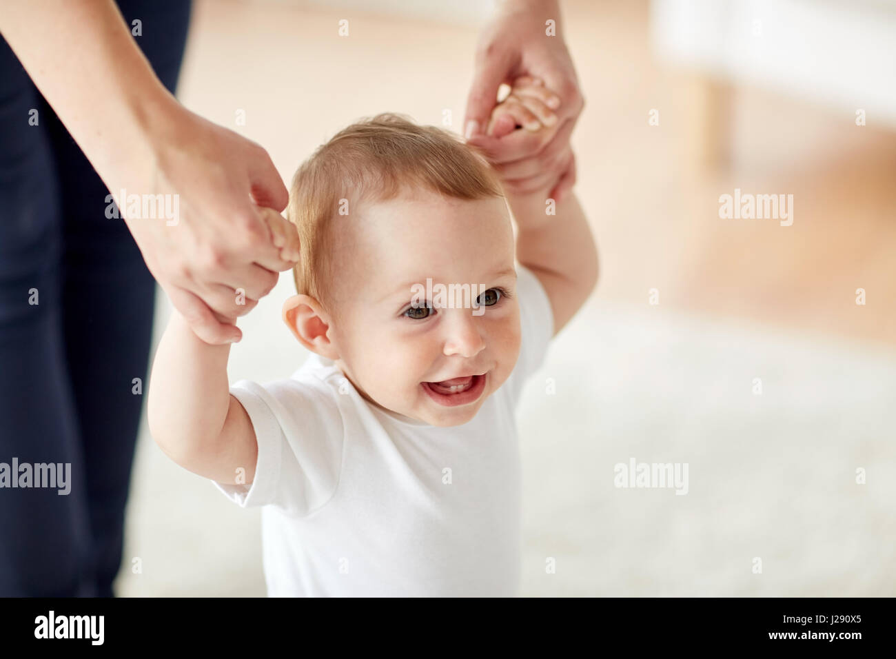 happy baby learning to walk with mother help Stock Photo - Alamy