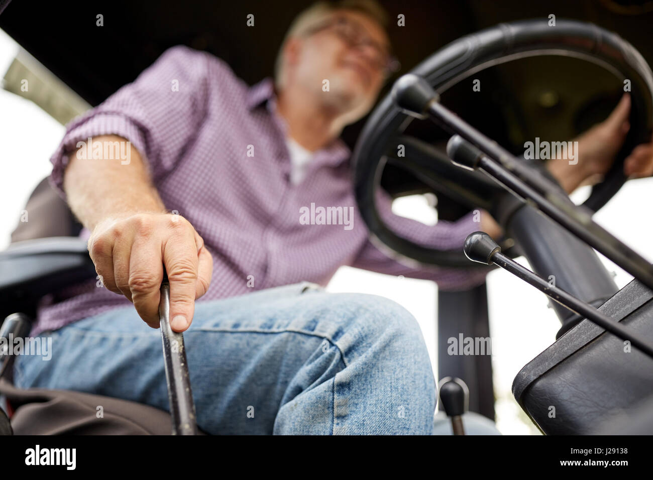 senior man driving tractor at farm Stock Photo - Alamy