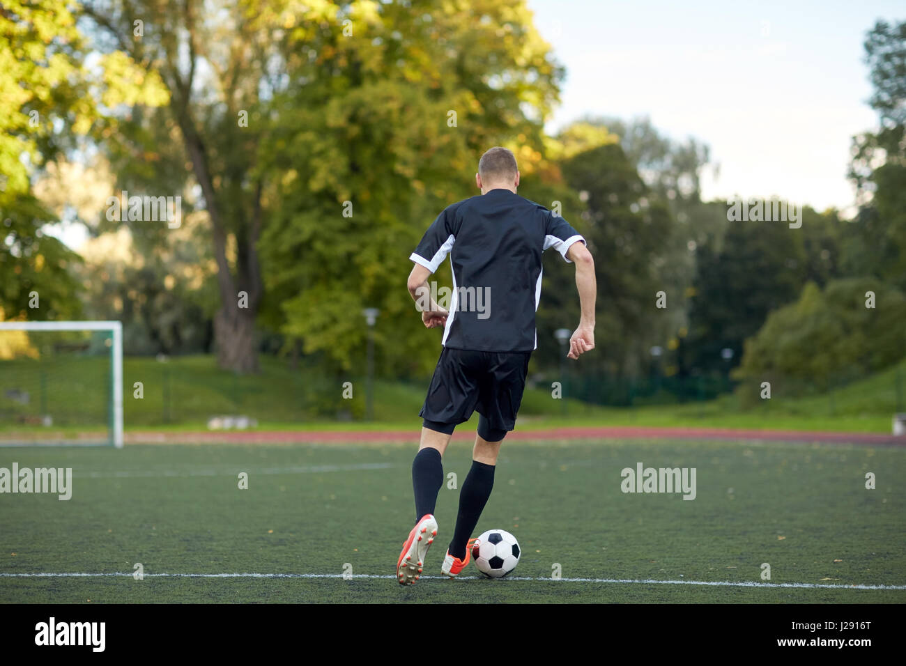 soccer player playing with ball on football field Stock Photo - Alamy