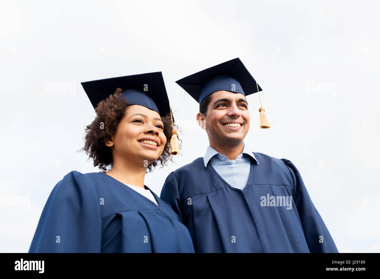 happy students or bachelors in mortarboards Stock Photo - Alamy