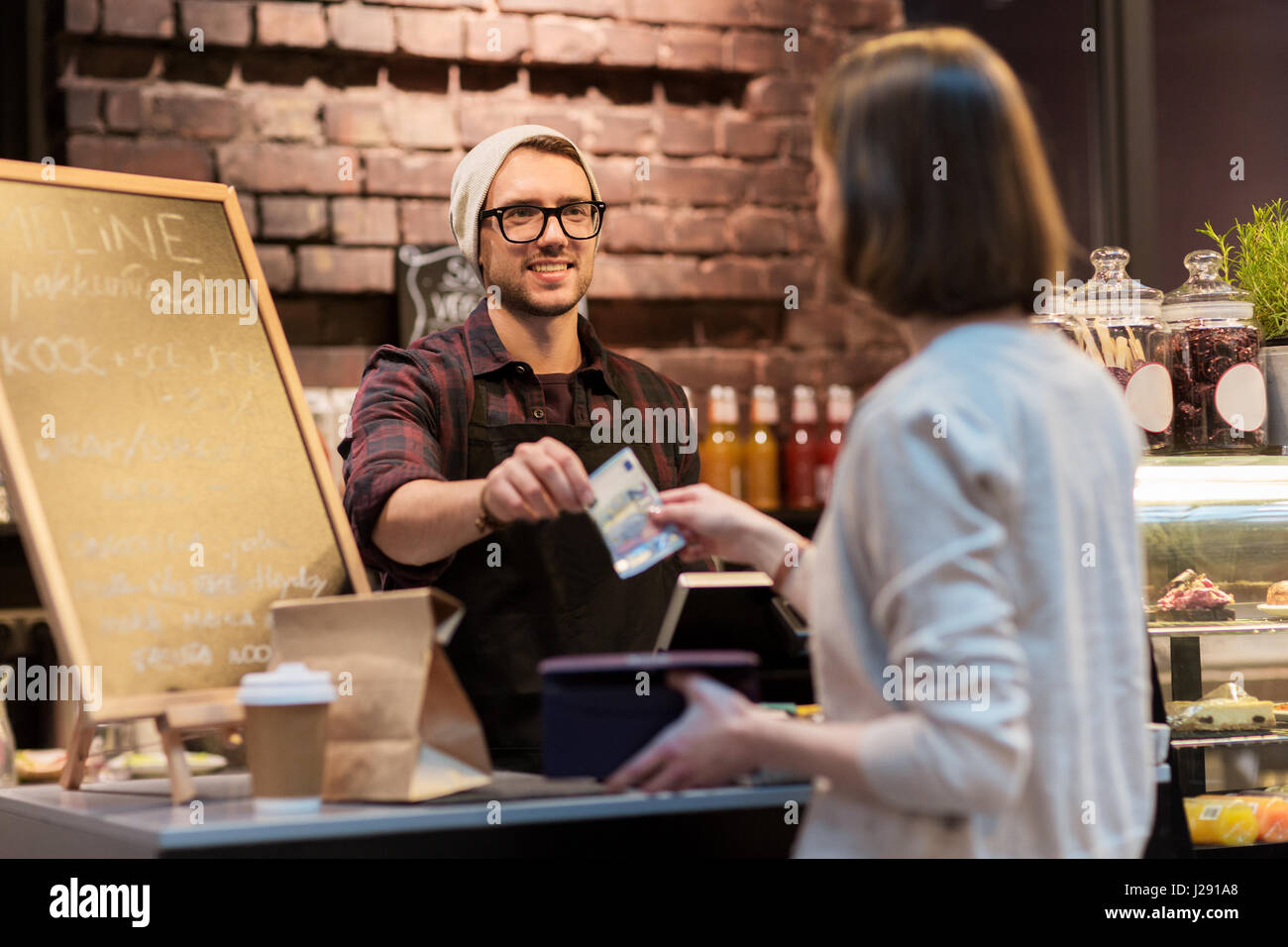 happy barman and woman paying money at cafe Stock Photo - Alamy