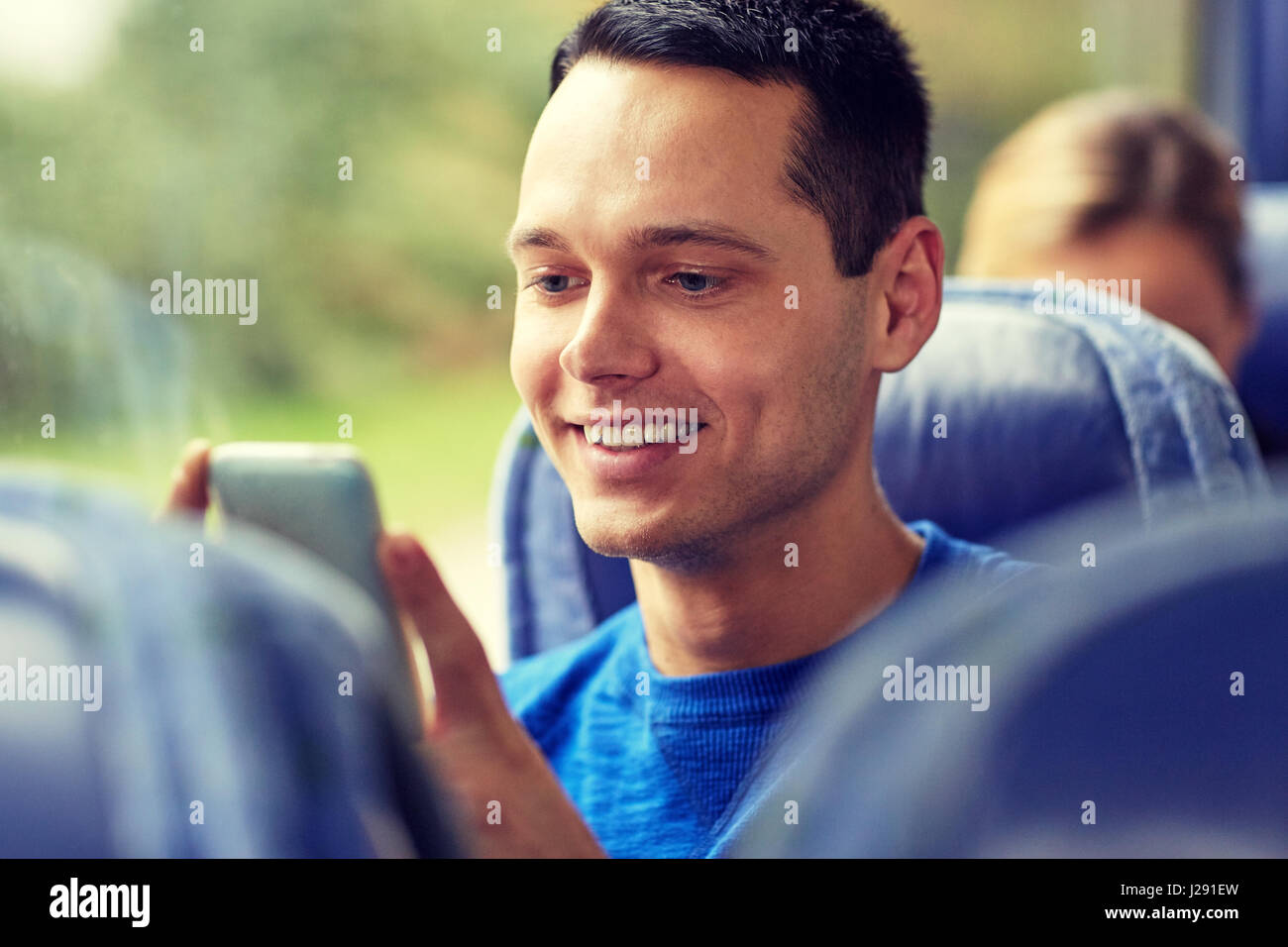 happy man sitting in travel bus with smartphone Stock Photo - Alamy