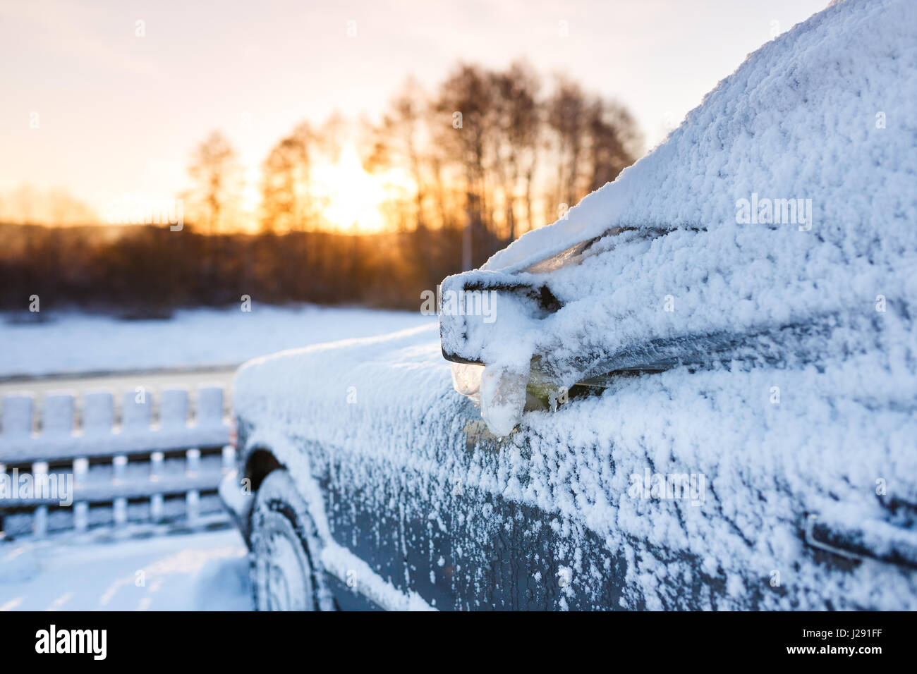 The snow-covered car in the parking lot in a winter dawn Stock Photo ...
