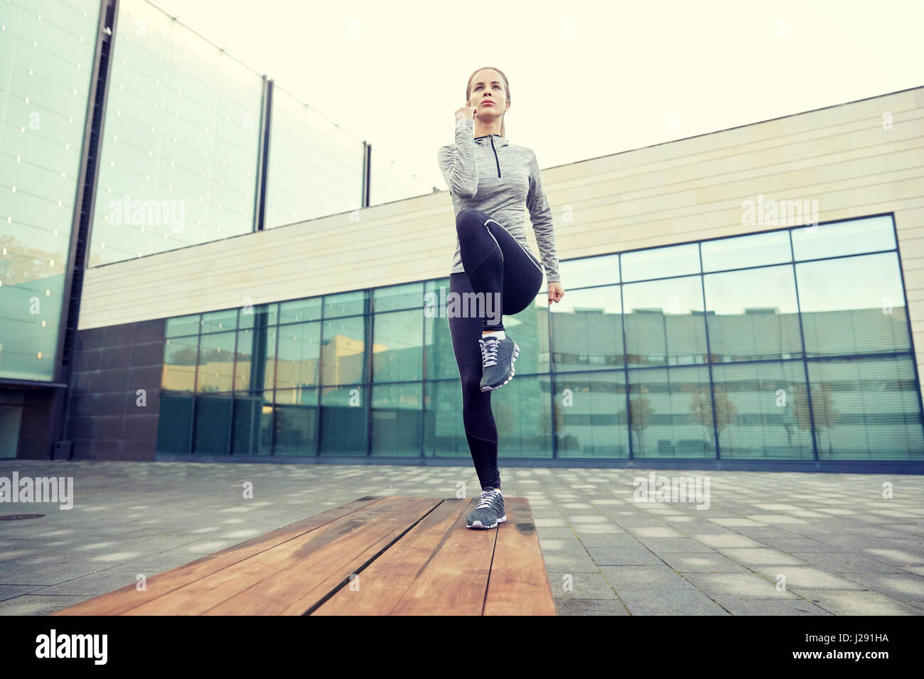 woman making step exercise on city street bench Stock Photo - Alamy