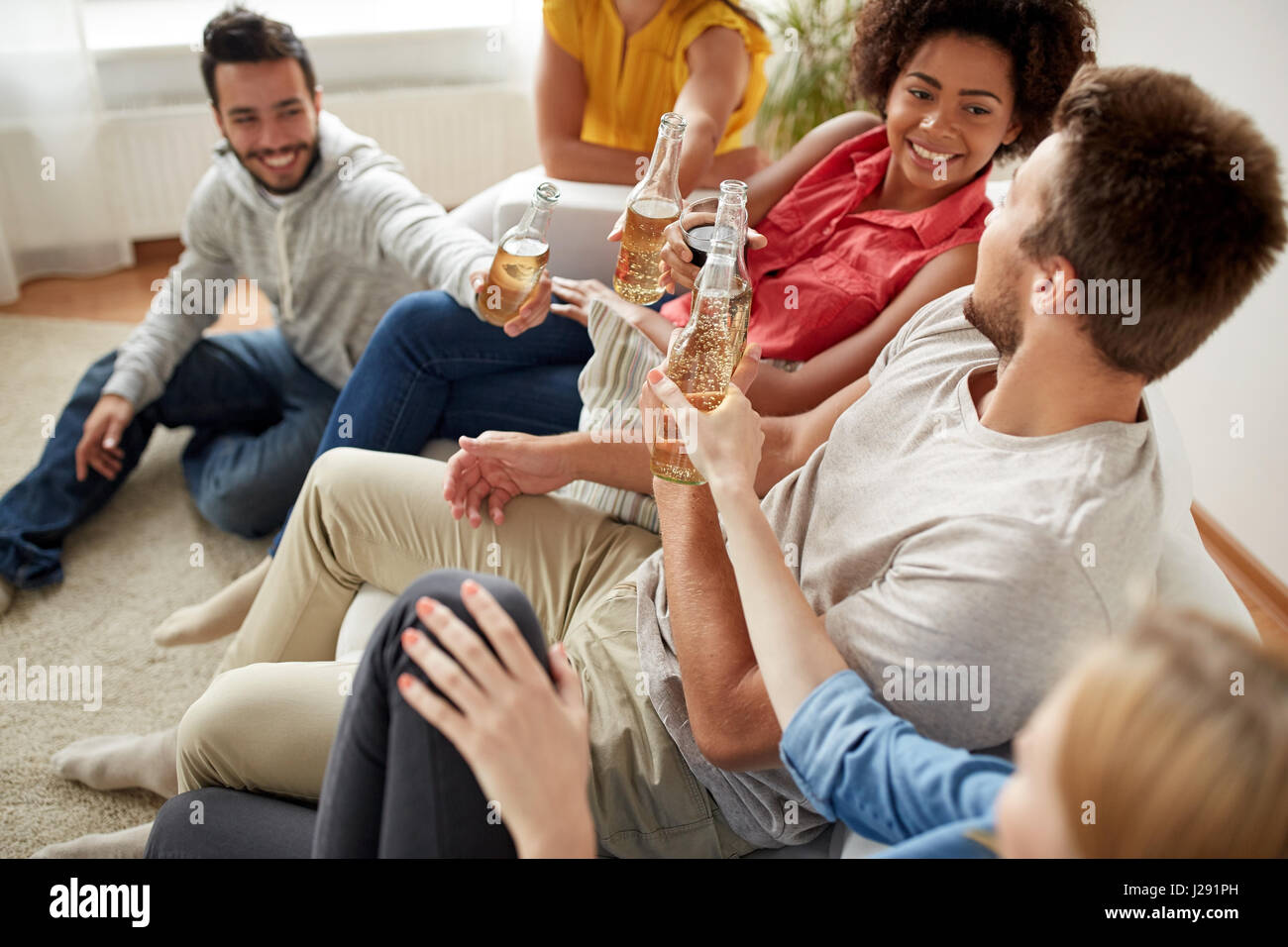 happy friends drinking beer at home party Stock Photo - Alamy