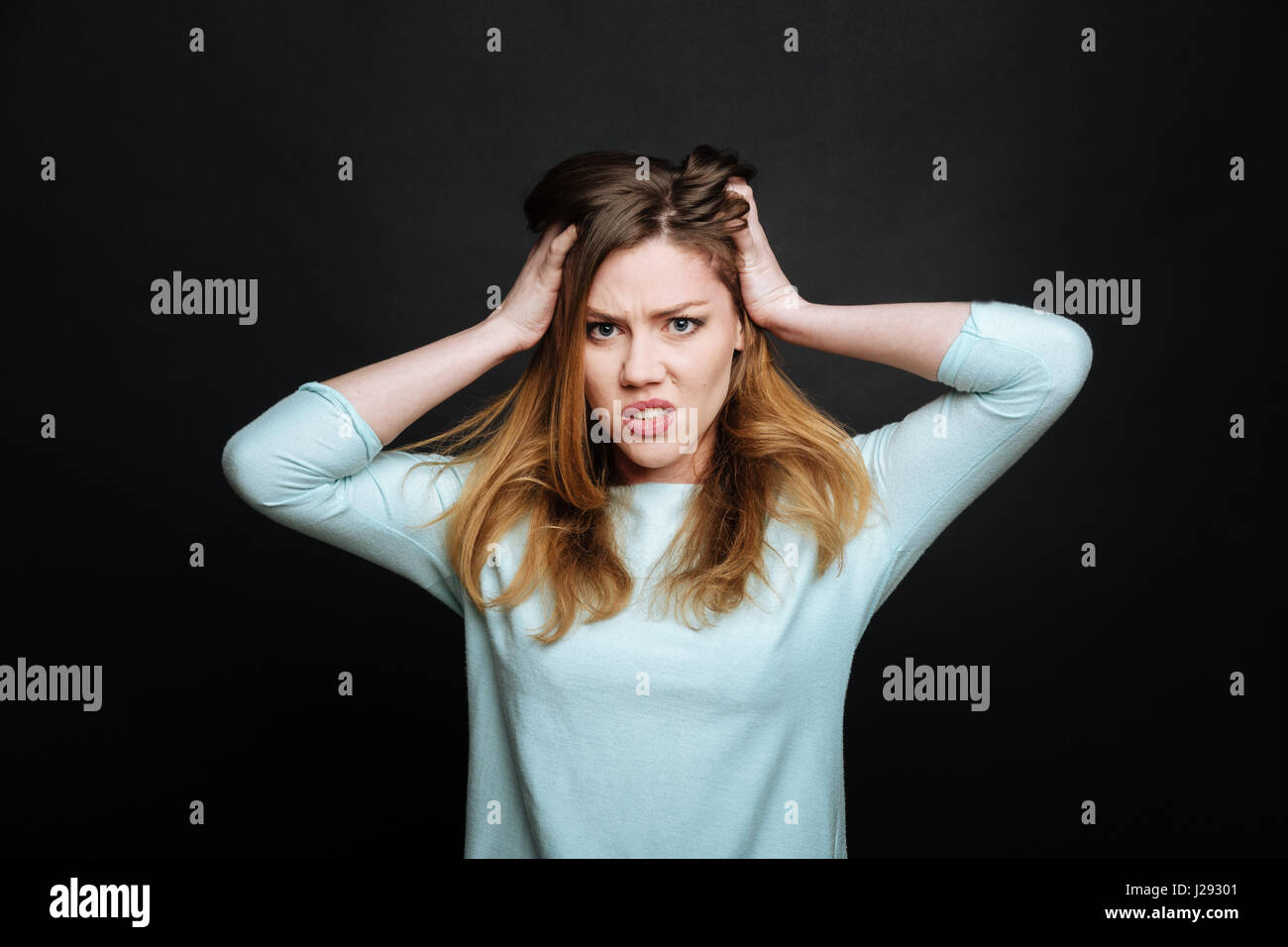 Angry young woman expressing disgust in the black colored studio Stock ...