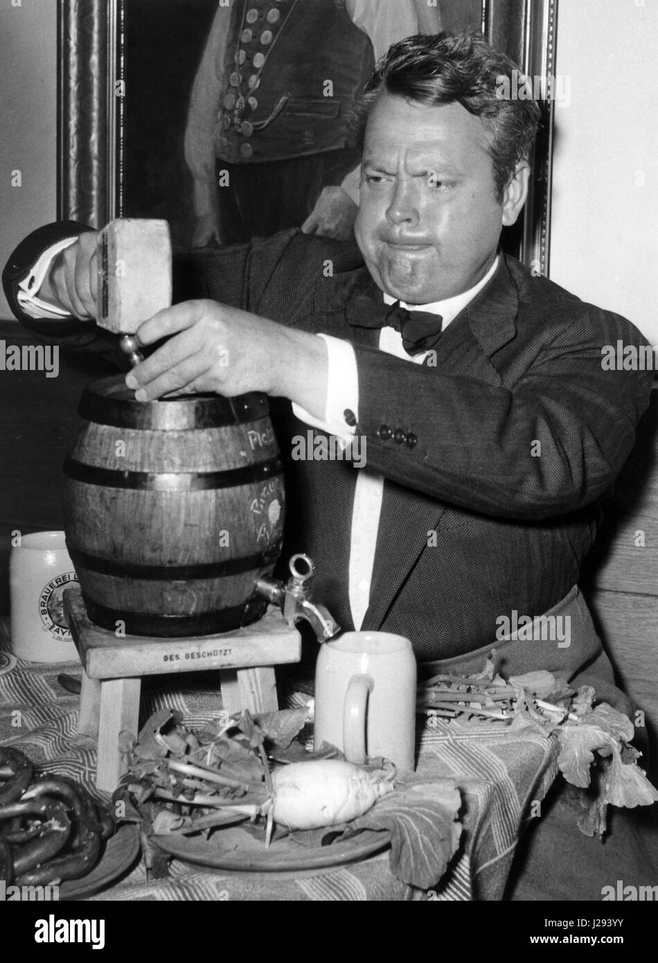 American director and actor Orson Welles jabs a three-liter-barrel at ...