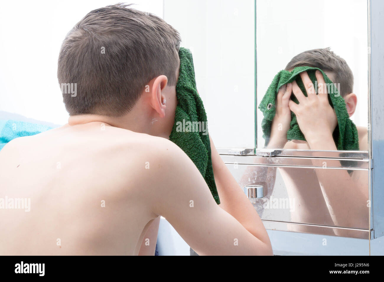 Young teenage boy washing his face with a flannel Stock Photo - Alamy