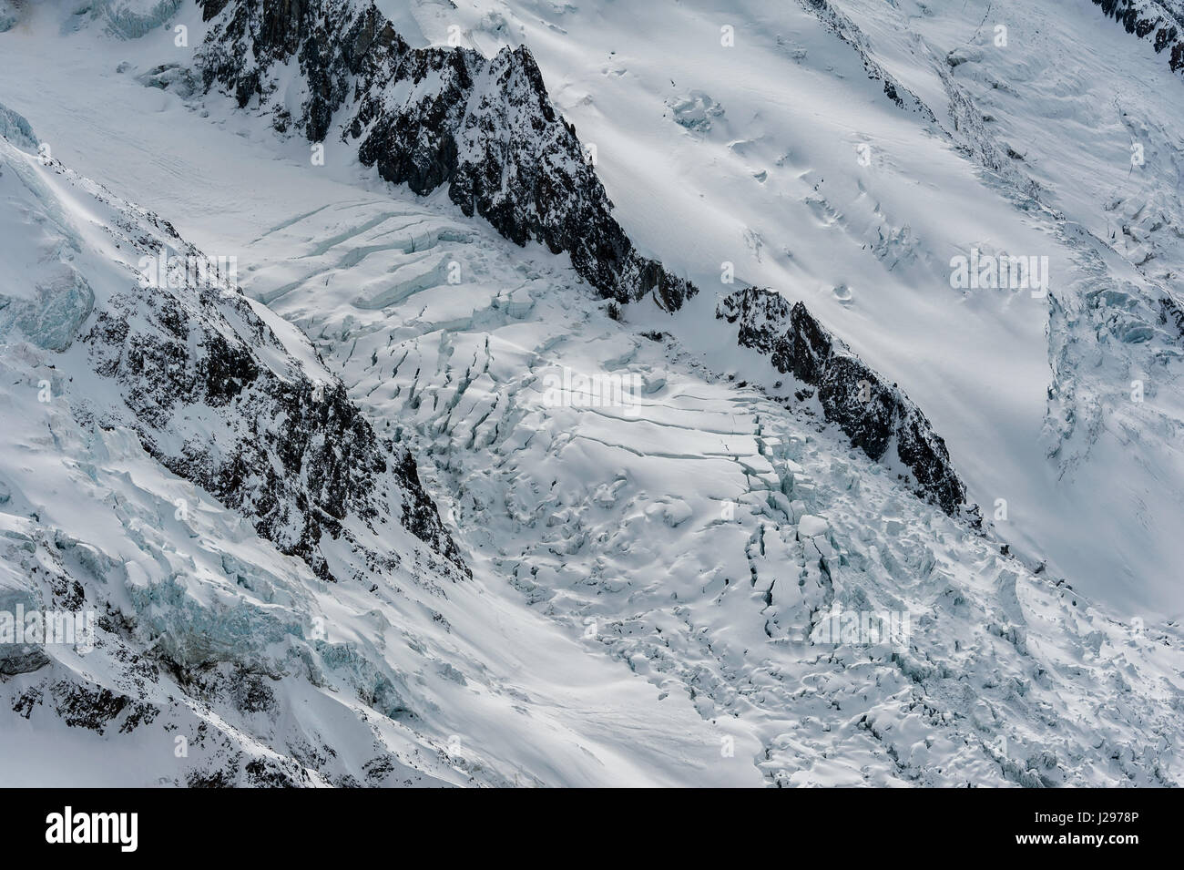 Aerial view of crevasses and seracs of Glacier des Bossons flowing down ...