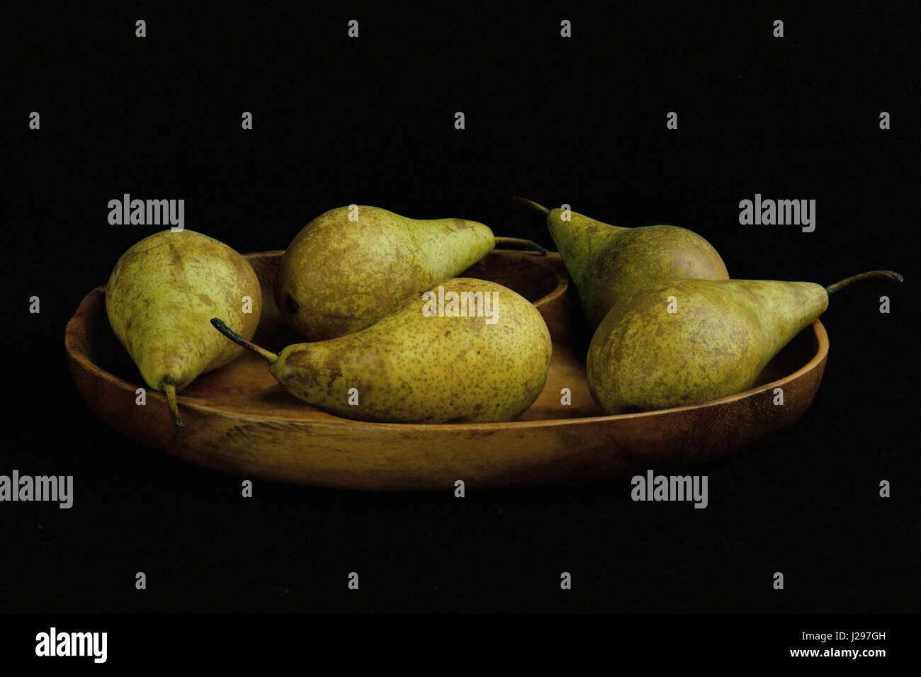 Five conference pears in wooden bowl Stock Photo - Alamy