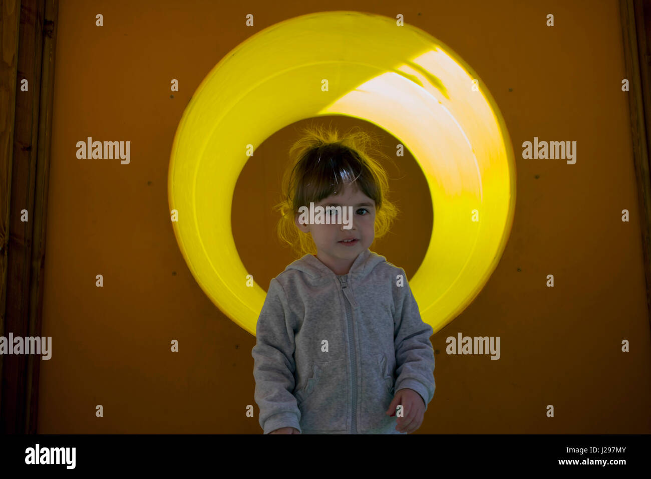 Cute little girl crawling through tube tunnel slide on children's ...
