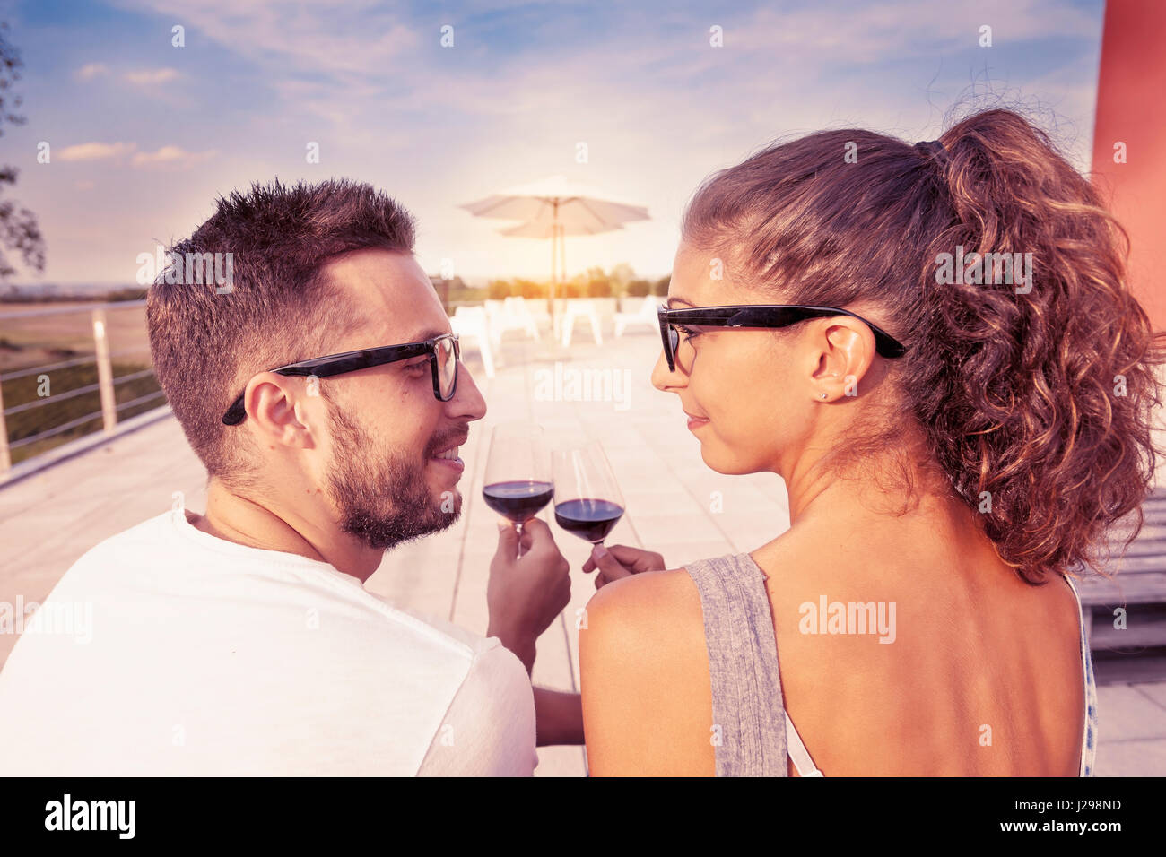 young couple toast on a terrace at sunset Stock Photo - Alamy