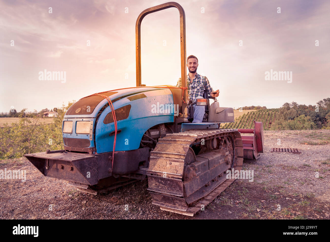 young farmer toasts on a crawler tractor in his vineyard Stock Photo ...